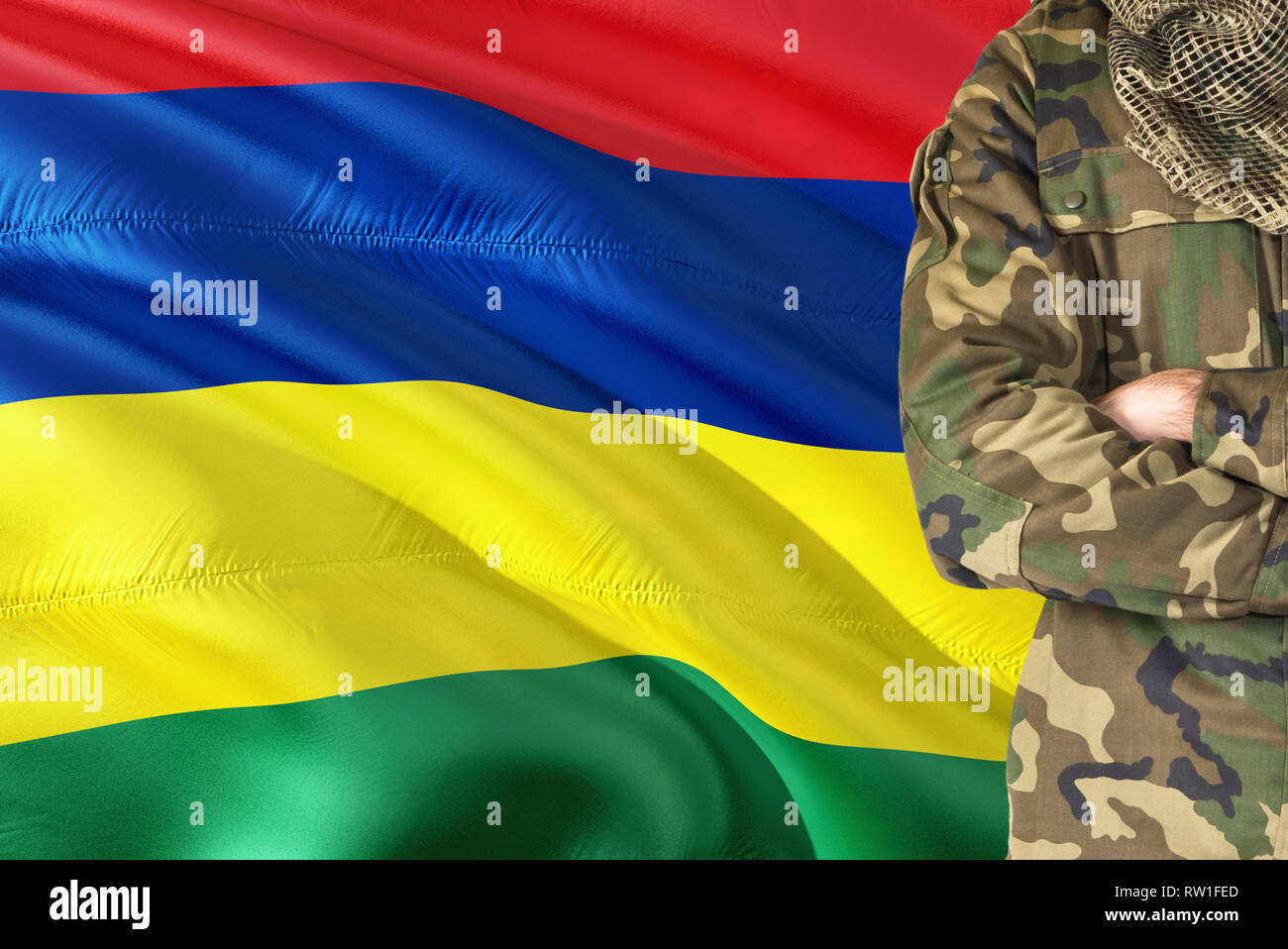 Crossed arms Mauritian soldier with national waving flag on background ...
