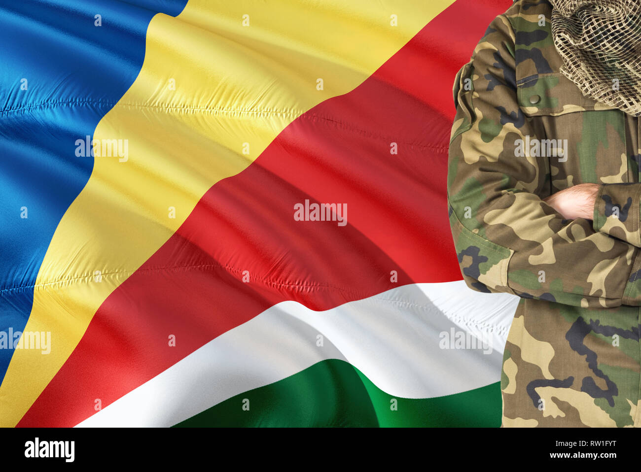 Crossed arms Seychellois soldier with national waving flag on ...