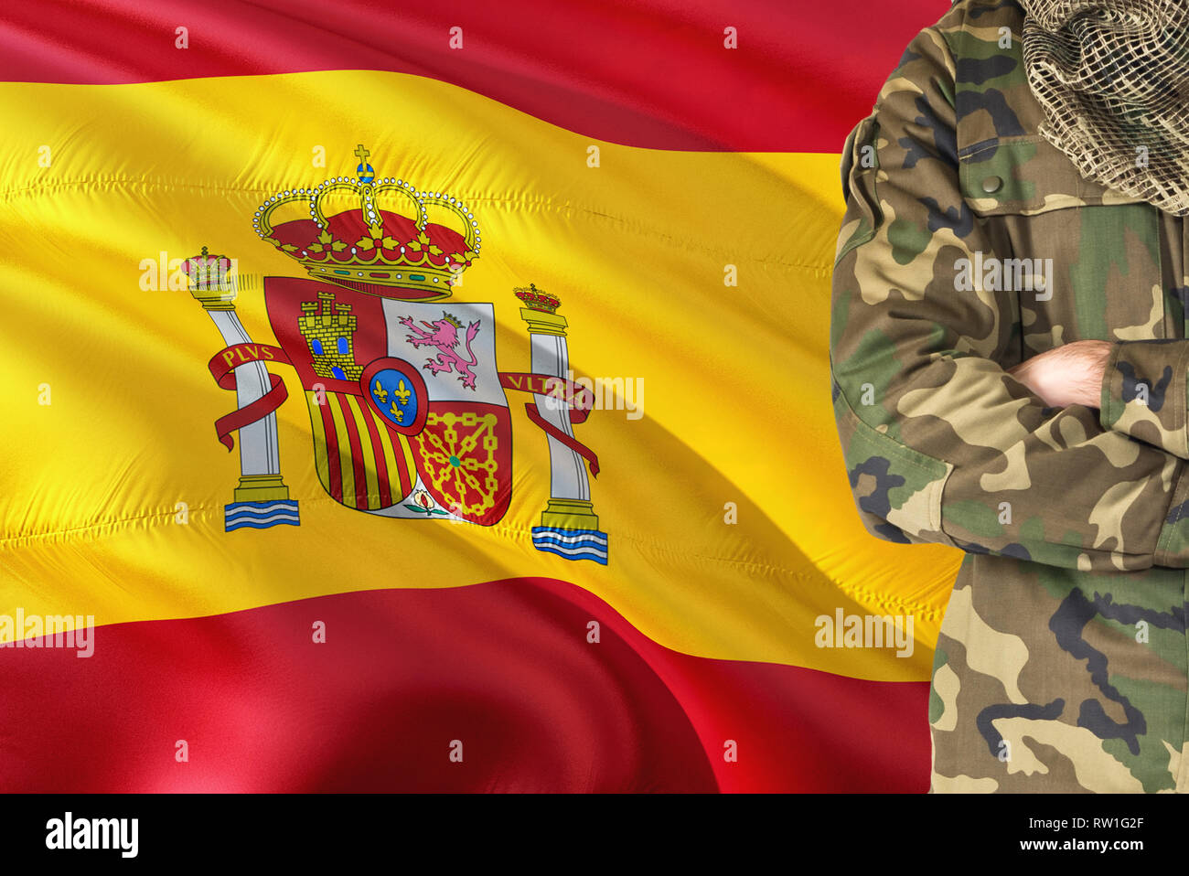Crossed arms Spanish soldier with national waving flag on background ...