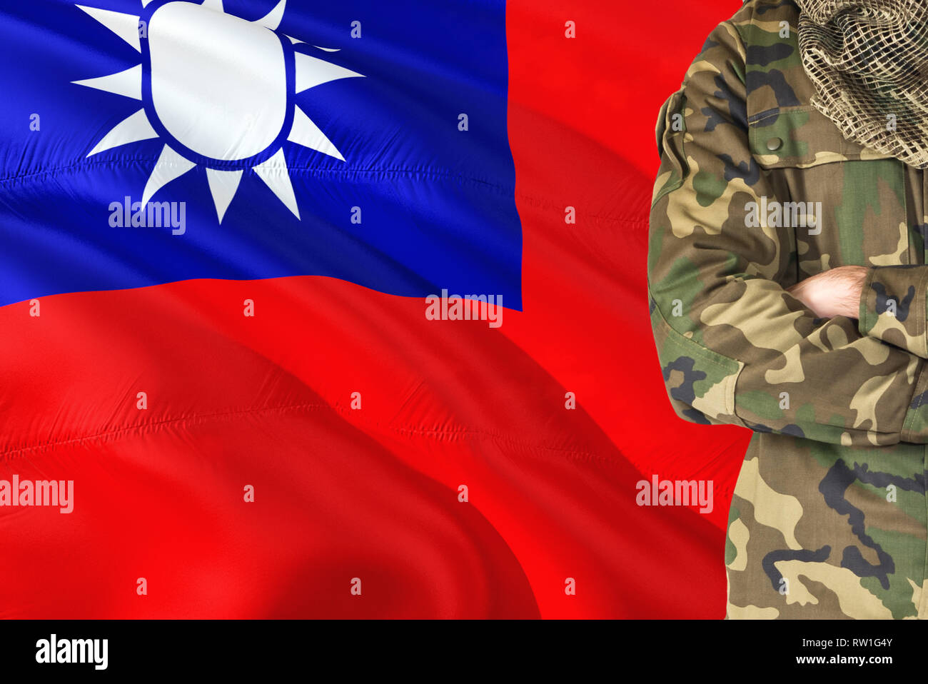 Crossed arms Taiwanese soldier with national waving flag on background ...