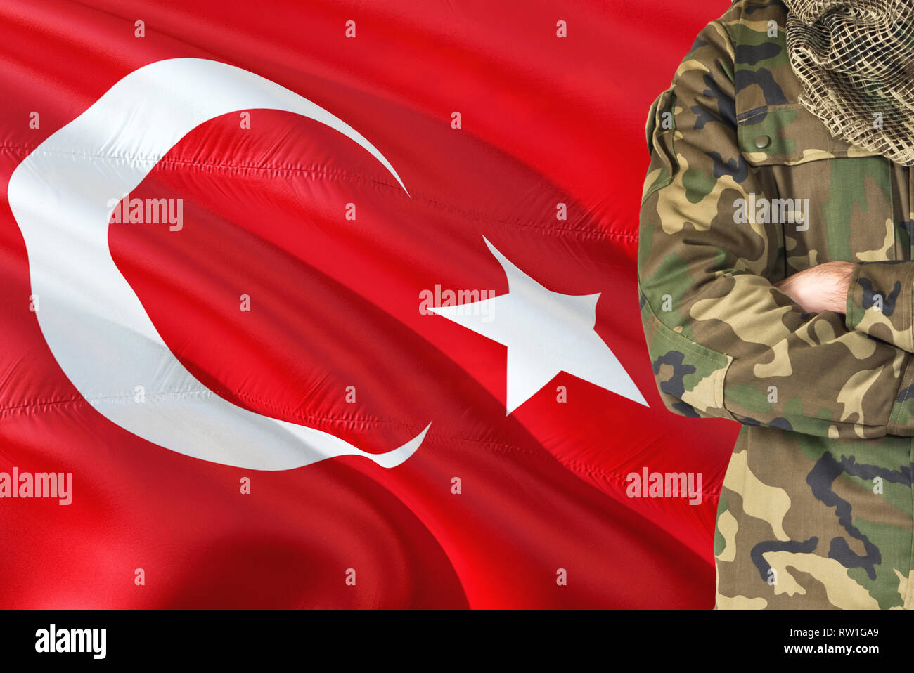 Crossed arms Turkish soldier with national waving flag on background ...