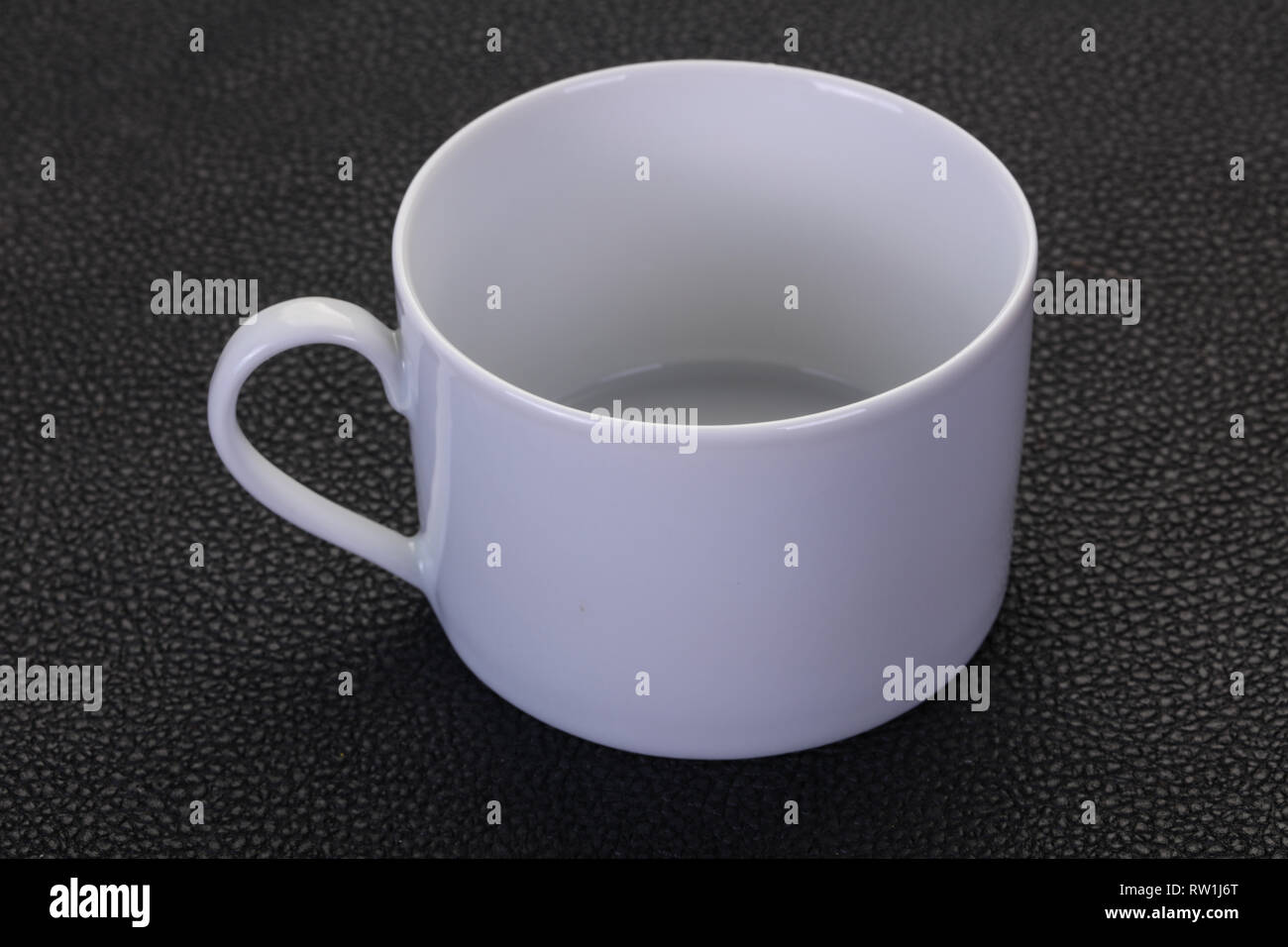 Empty ceramic cup over black background Stock Photo - Alamy