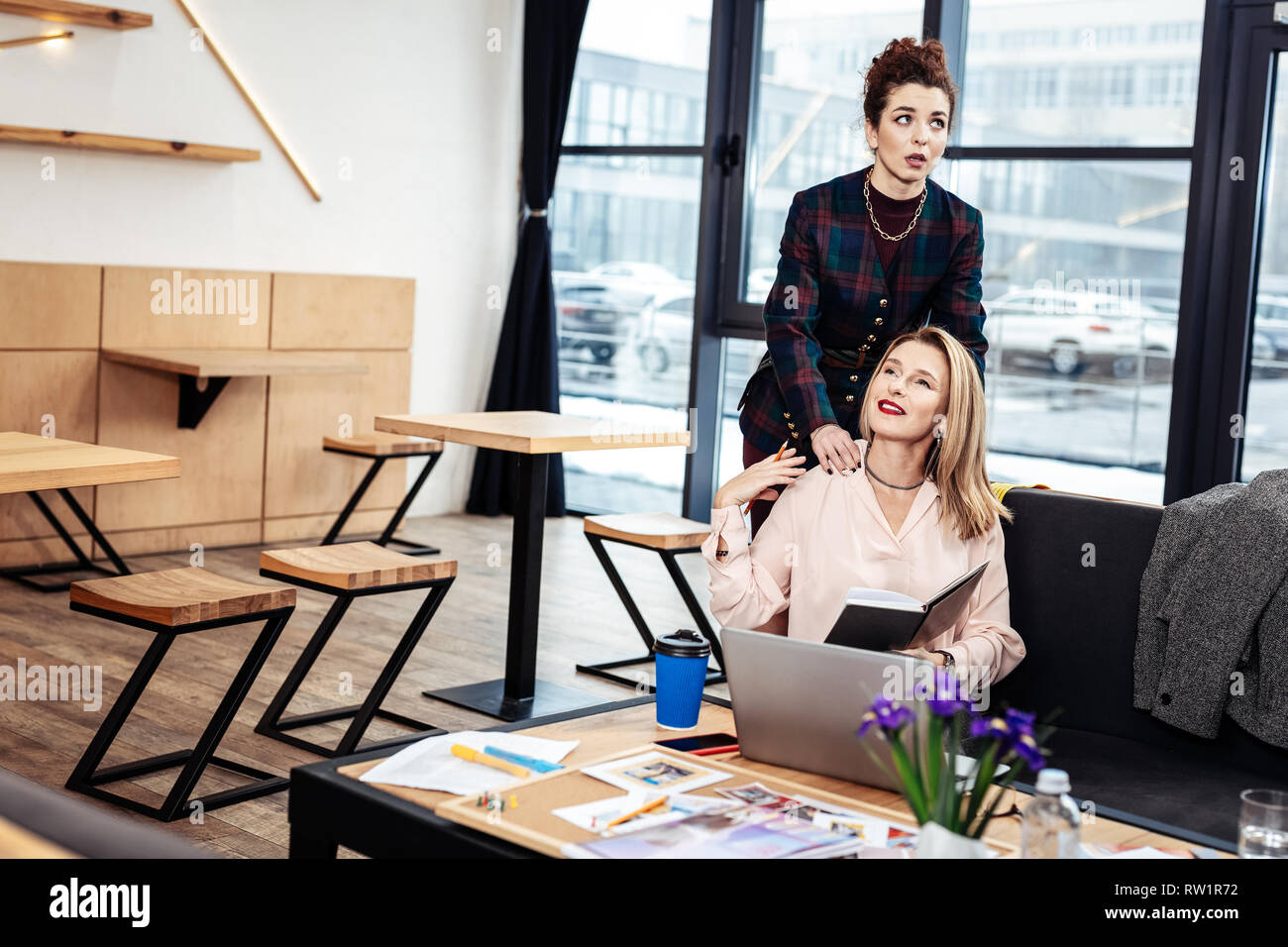 Curly dark-haired secretary feeling tired of her demanding boss Stock ...