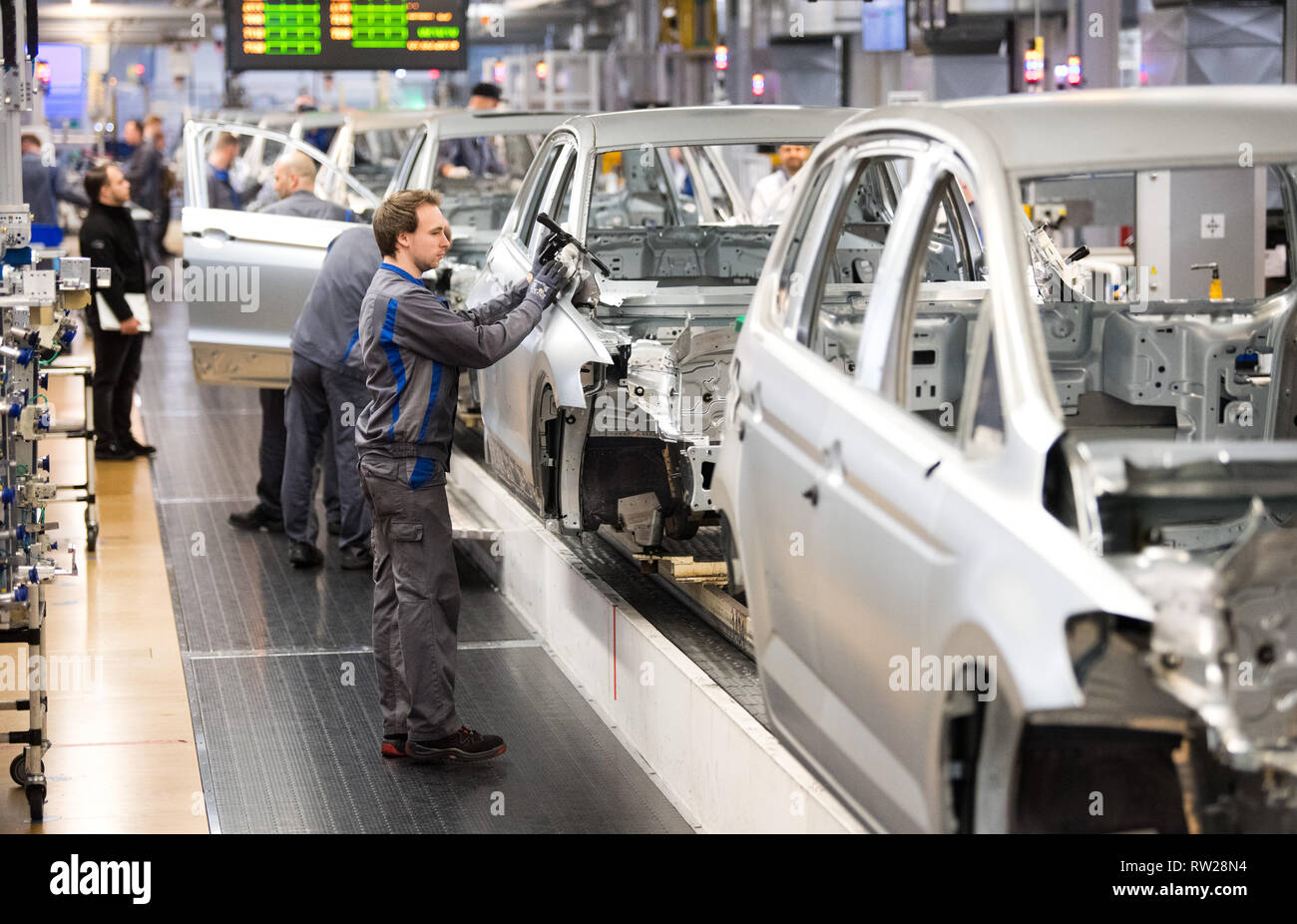 Wolfsburg, Germany. 01st Mar, 2019. Employees fit fenders to a ...