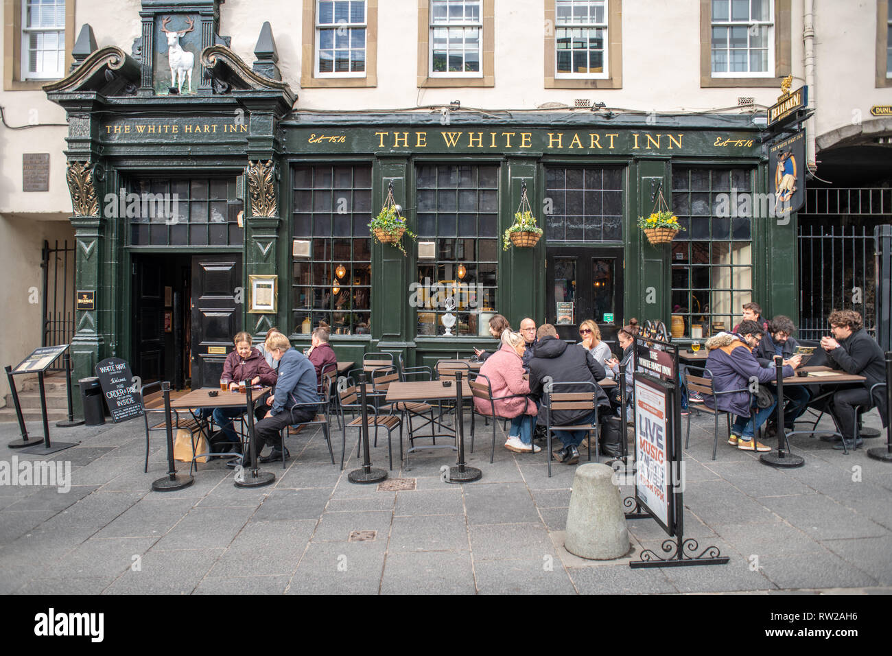People sitting and enjoy a pint together at outdoor seating area in ...