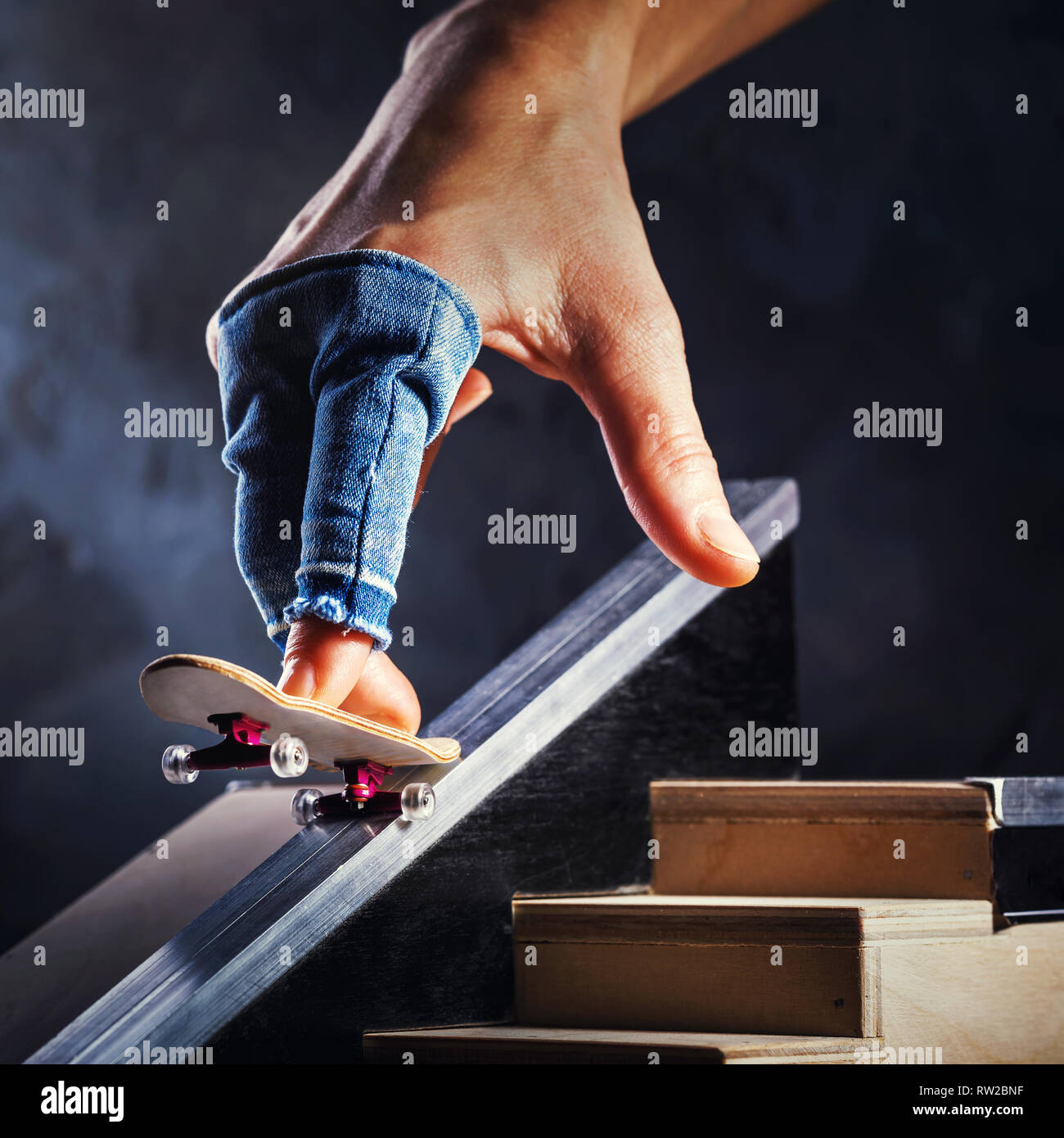 Riding a mini skateboard on a special track. Hand with fingerboard ...