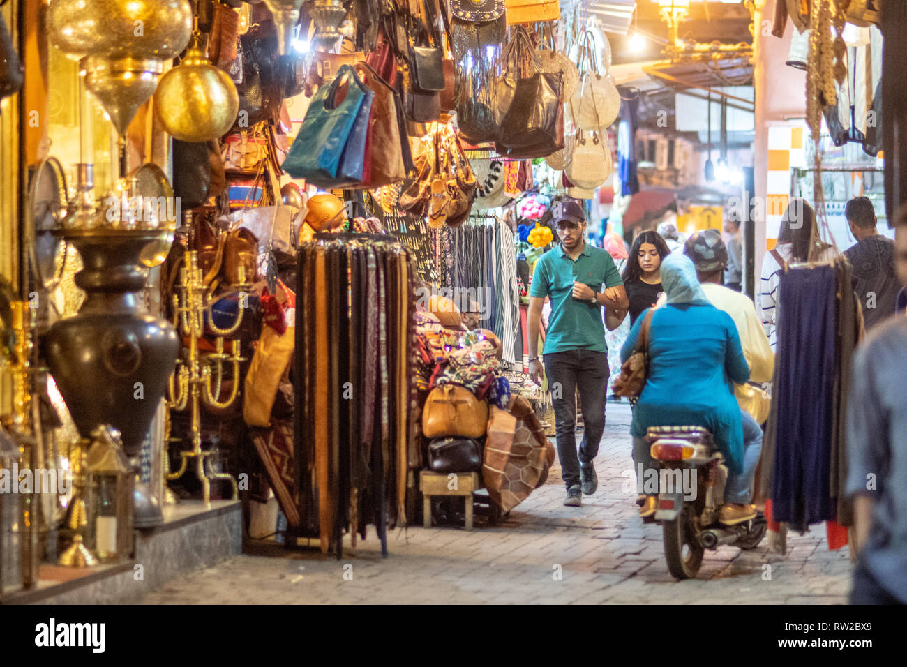 Shoppers walk the streets of medina quarter of Marrakesh at night past ...