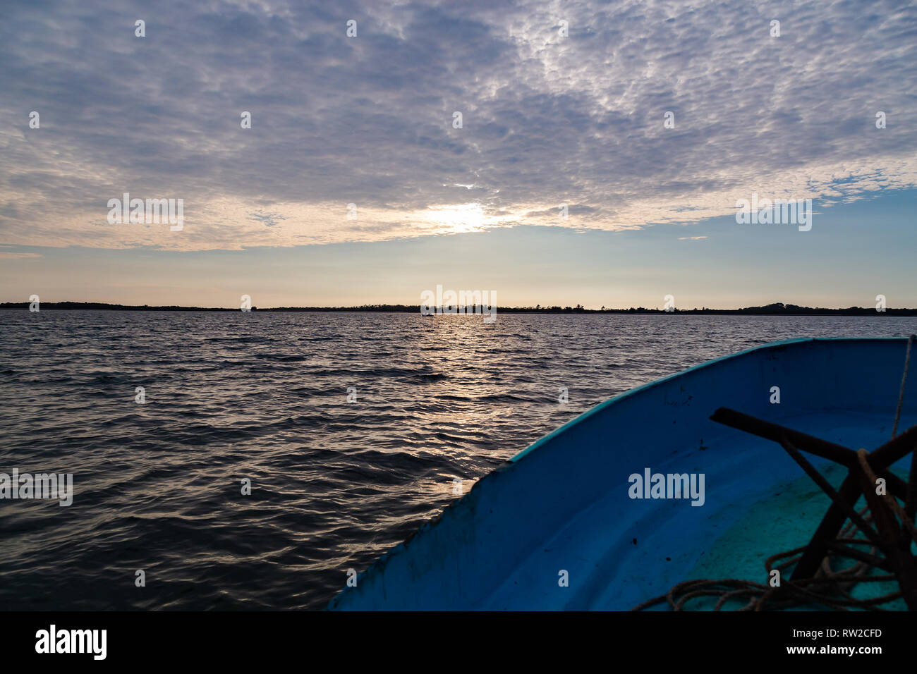 Strange sunset with bright clouds over the sun and the sea with a ...