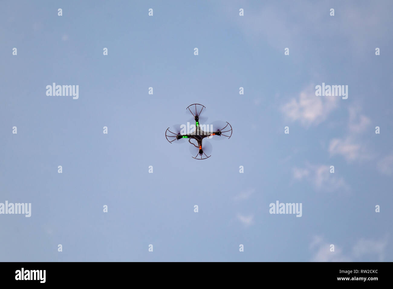 Small generic drone with its lights, flying with a light blue ...