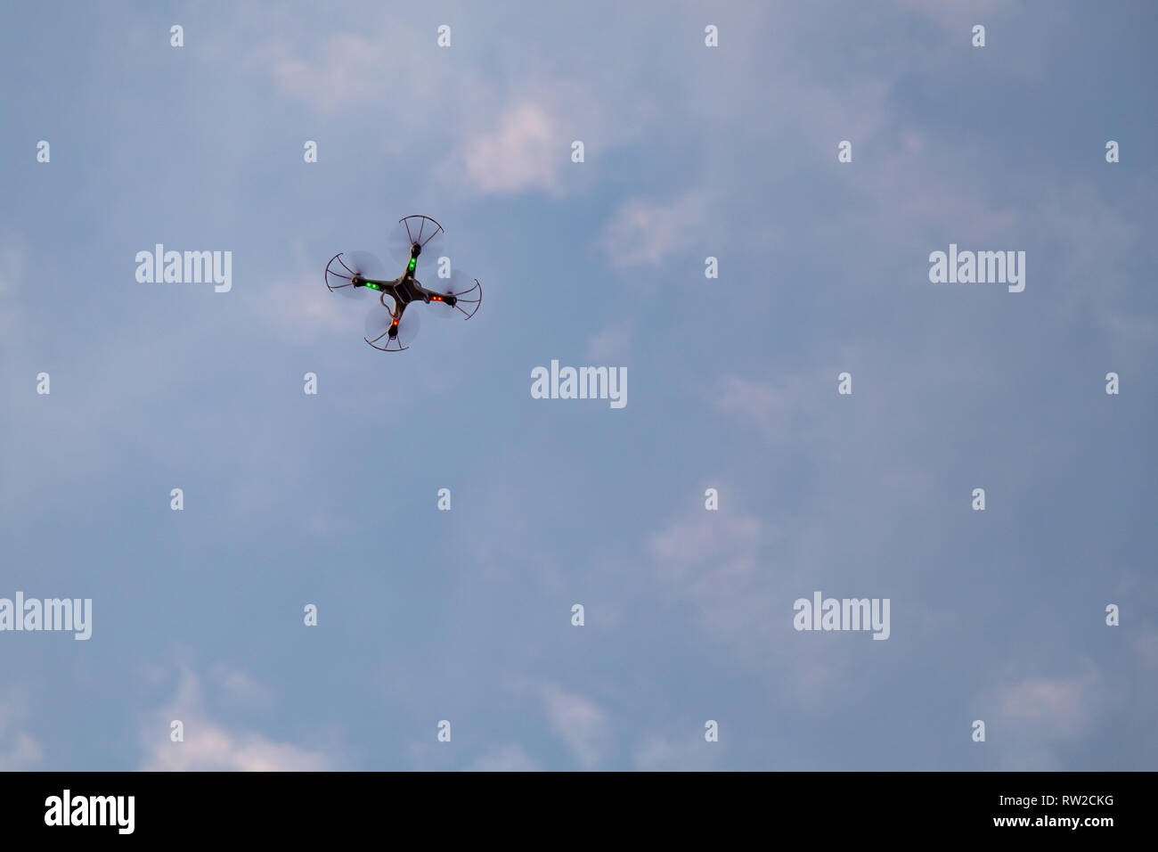 Small generic drone with its lights, flying with a light blue ...