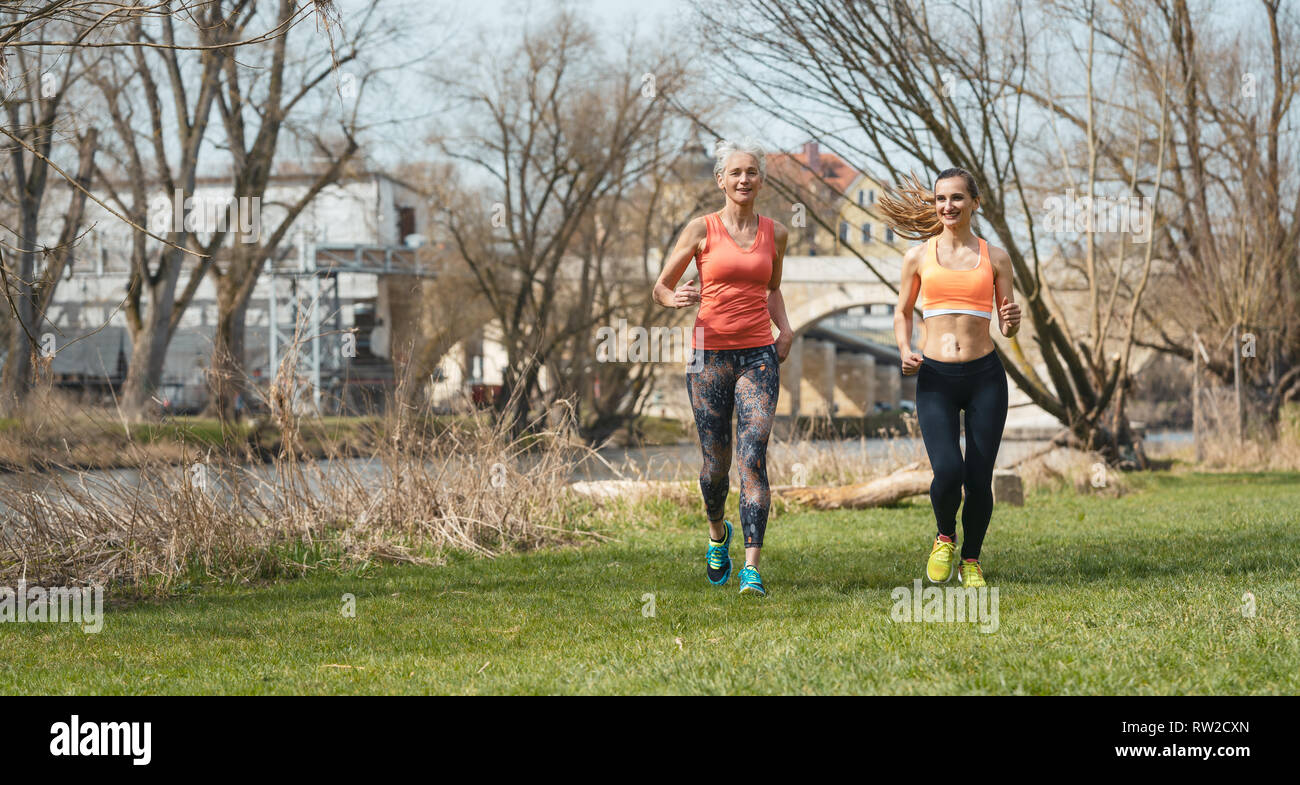 Old and young woman running for sport on spring day Stock Photo - Alamy
