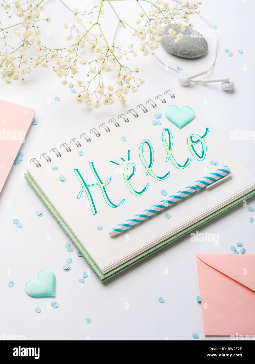 Spring girl's items flat lay on white. Hello word written on notebook ...
