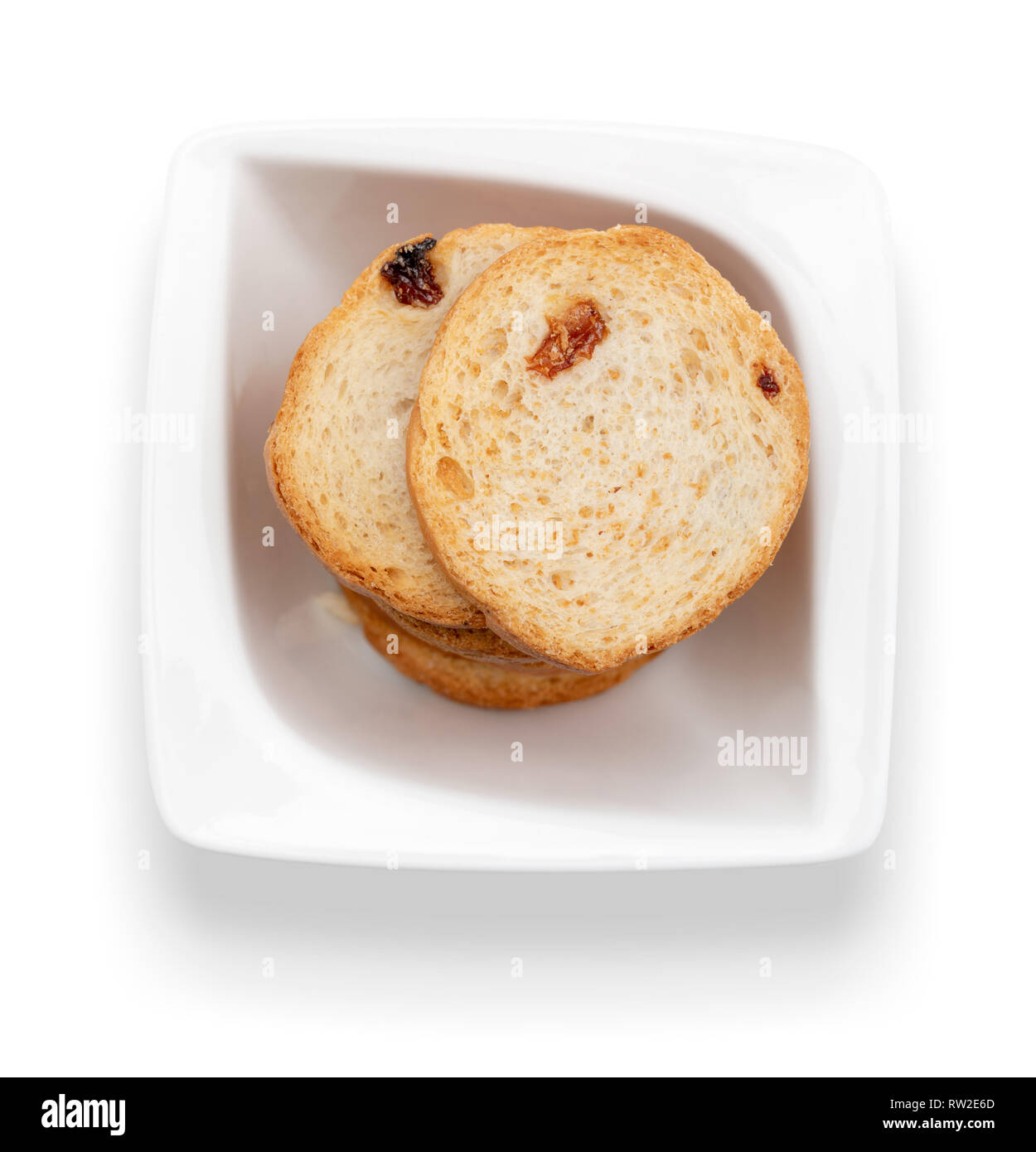 Mini round toasts of bread with raisins in white bowl. Top view ...