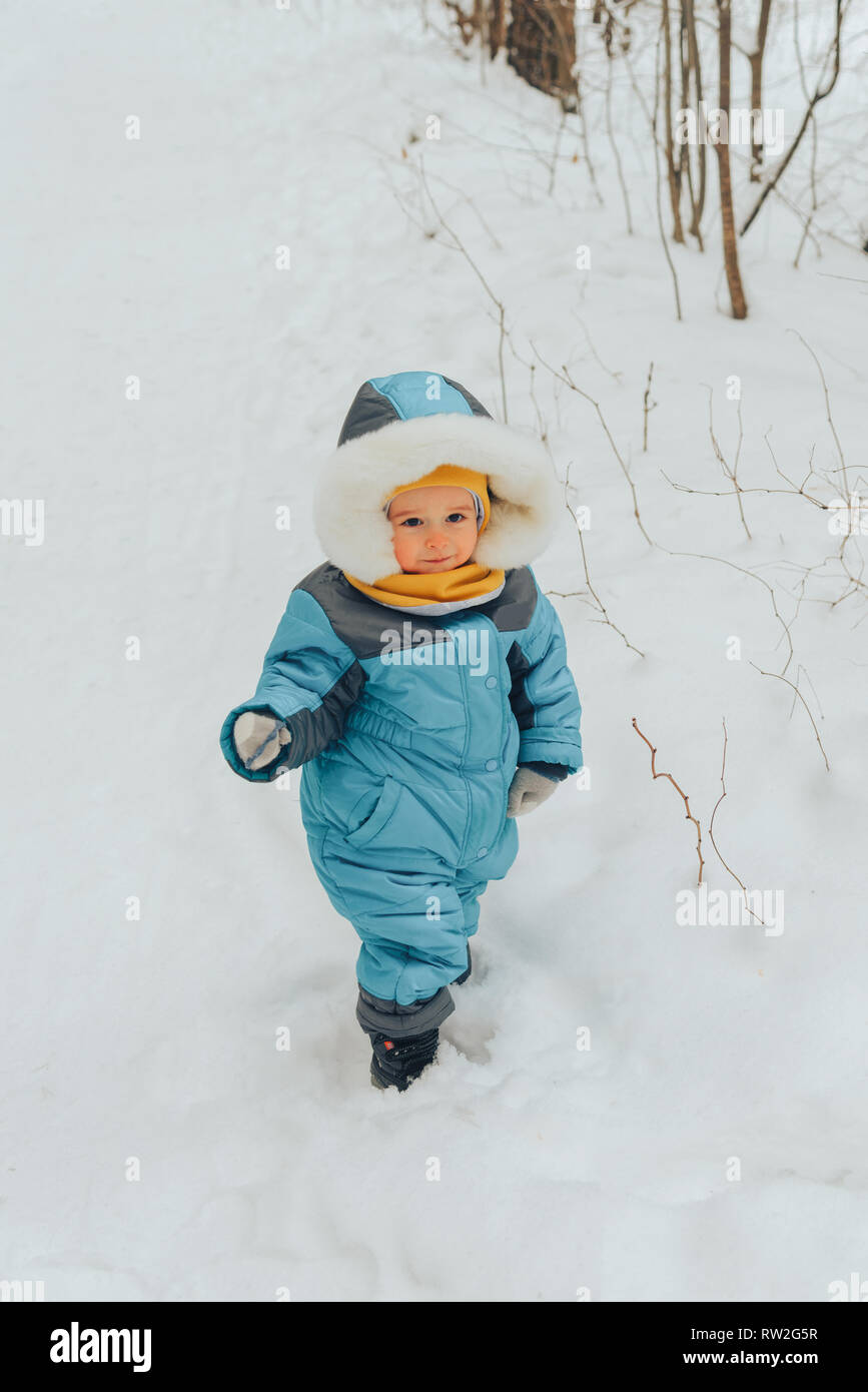 A child for a walk in the winter. Kid in winter clothes. Family walks ...