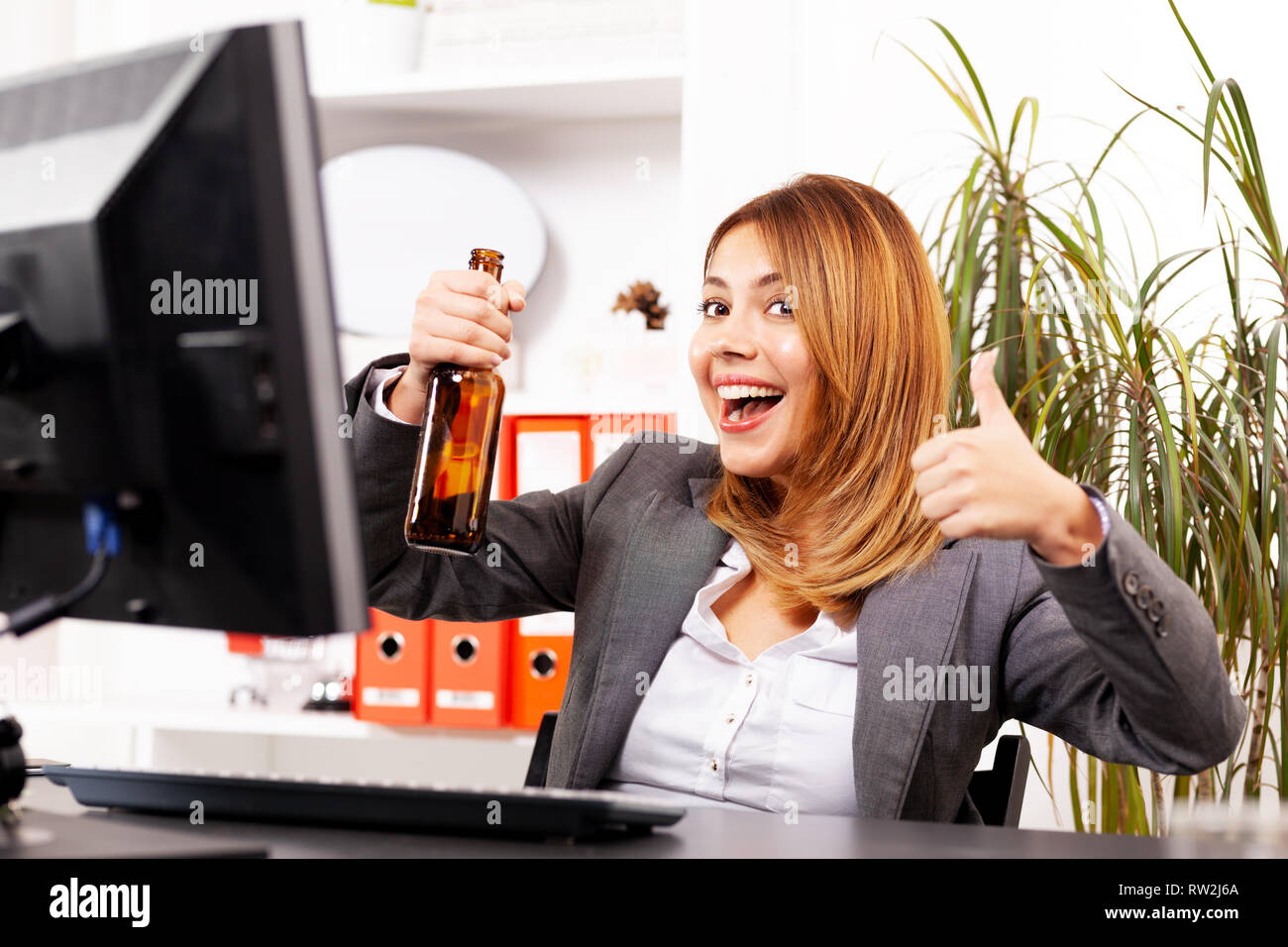 happy business woman drinking beer in an office Stock Photo - Alamy