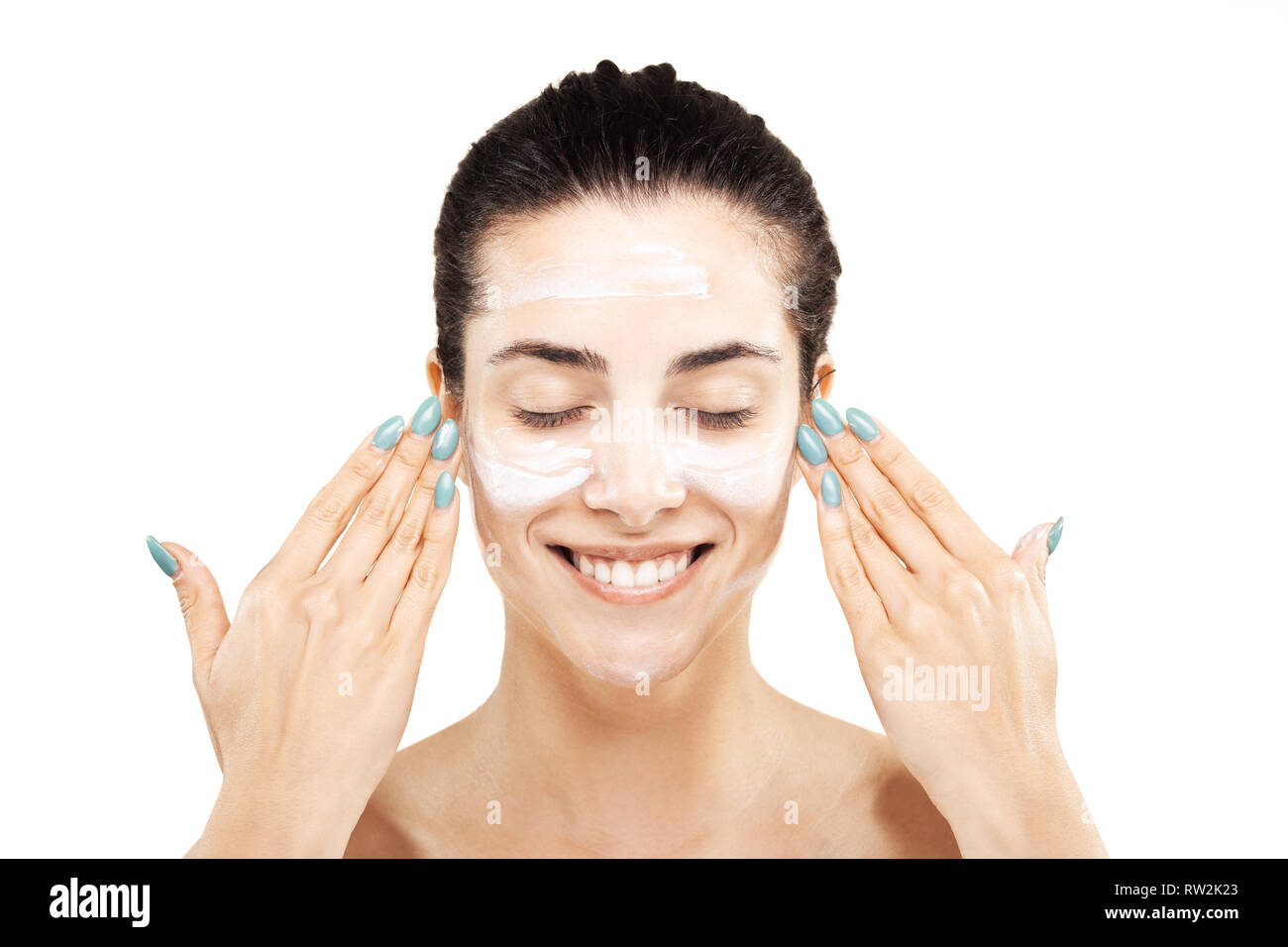 beautiful girl putting cream on her face with a smile Stock Photo - Alamy