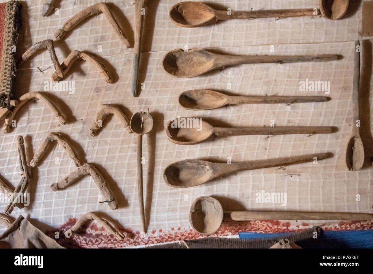 Crude wooden spoons and other tools used by Berber nomads hung on wall ...