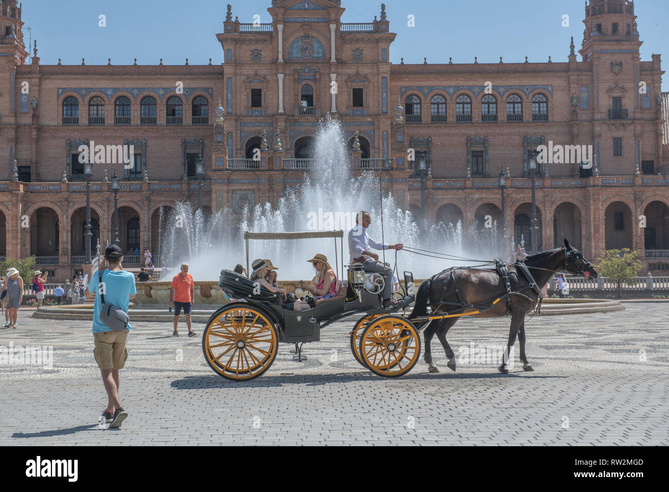 Tourist ride a horse drawn carriage in Plaza de Espa–a -Seville , Spain ...