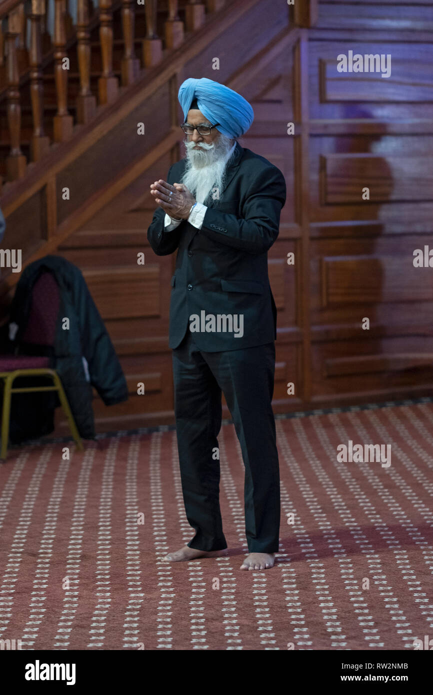 A devout Sikh man stands in prayer and meditation in a temple in South ...