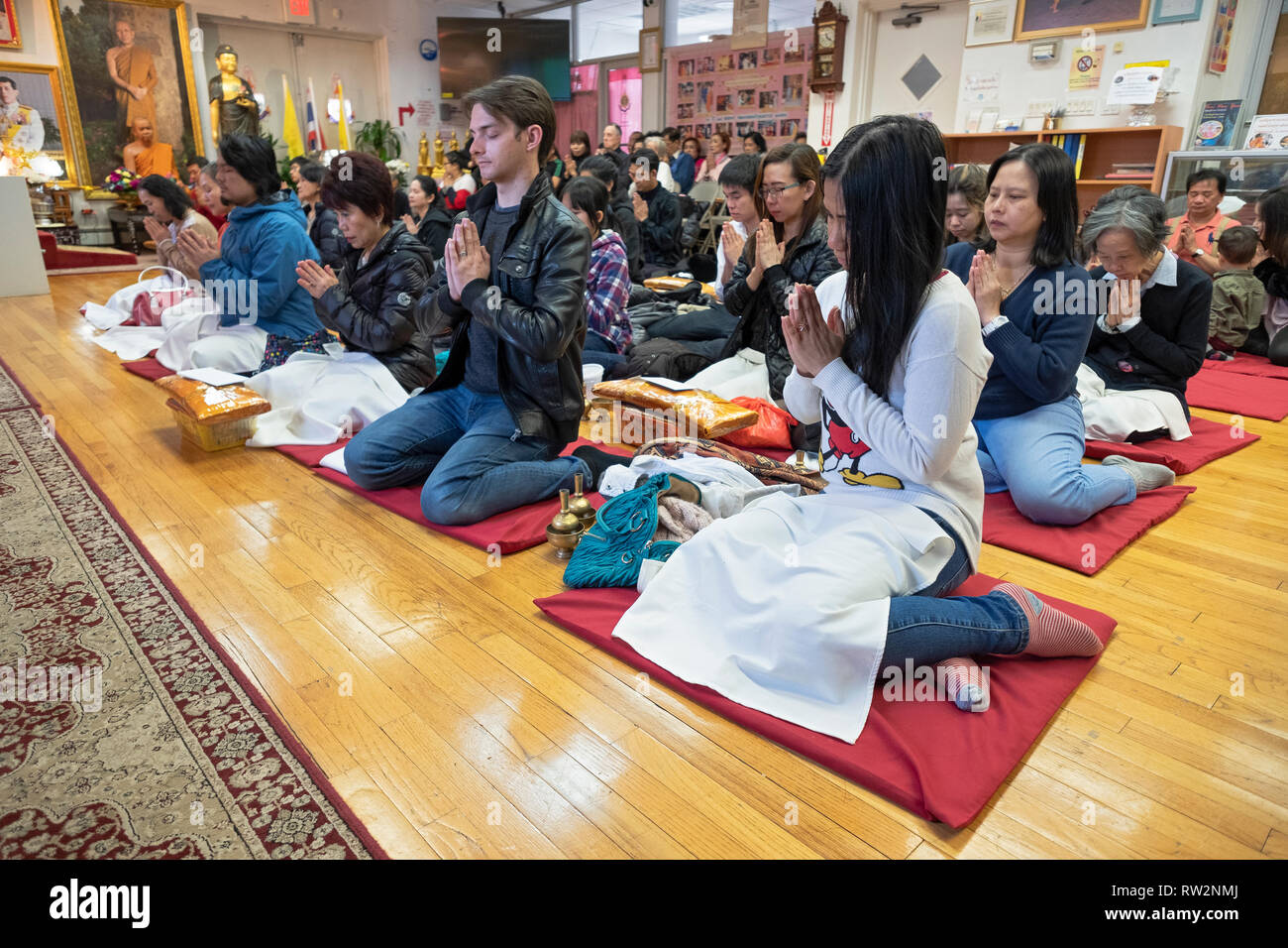 Buddhist worshippers, many from Thailand, pray & meditate at a temple ...