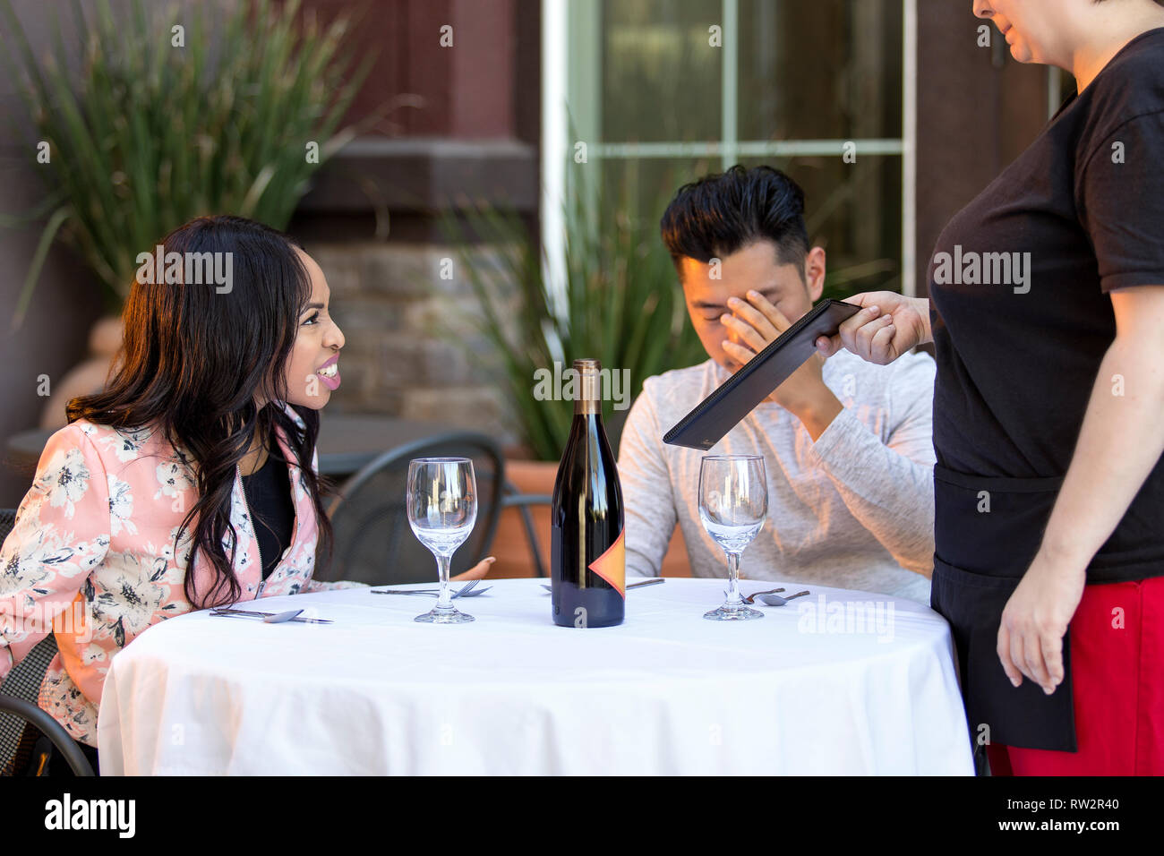 Couple on a date angry at a waitress in an outdoor restaurant. They are ...