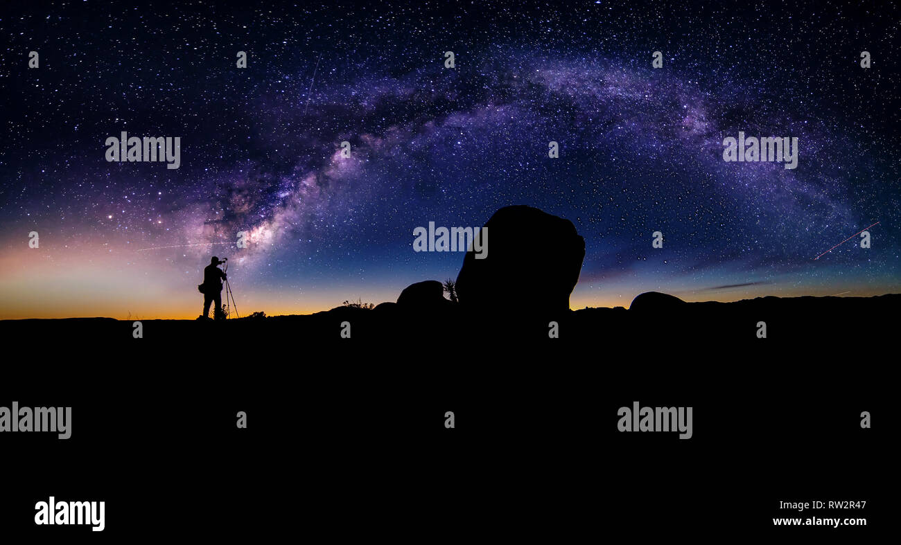 Photographer doing astro photography in a desert nightscape with milky ...