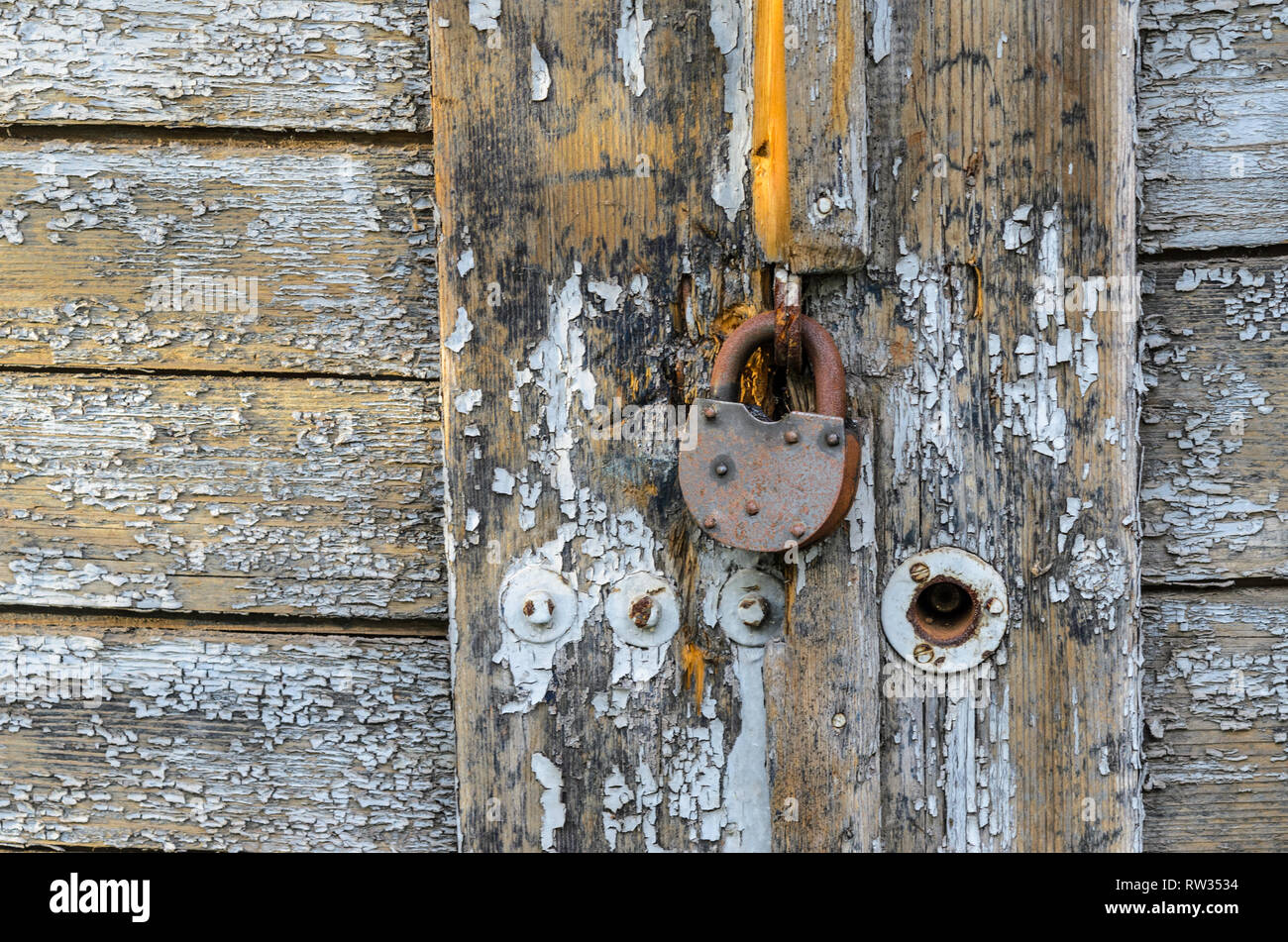 Rusty old lock on the wooden doors. Lock on the door of an old ...