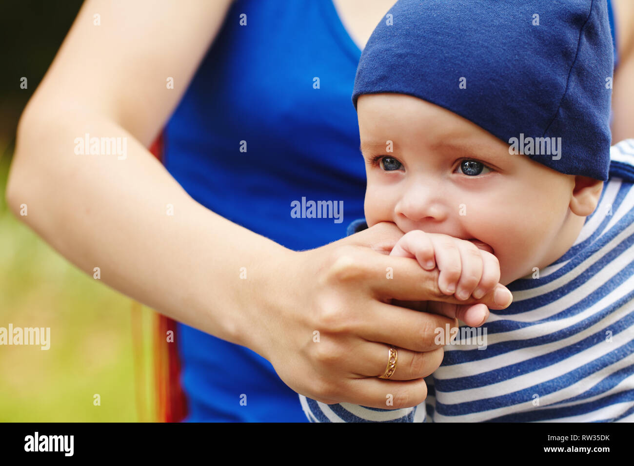 portrait of a baby holding his mother's hand. Mom and son Stock Photo ...
