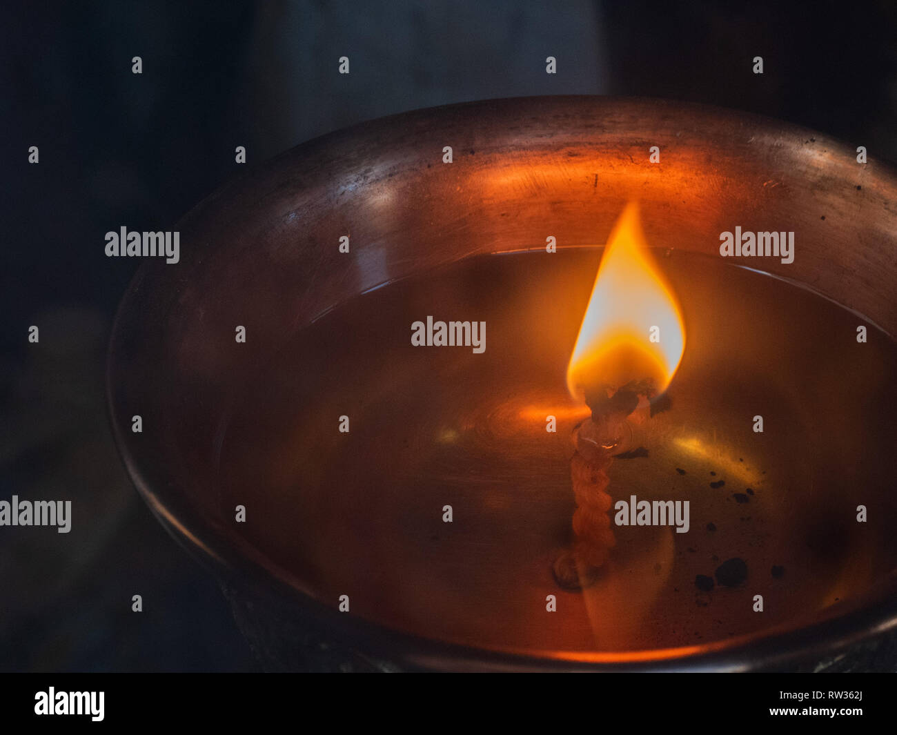 Burning fire in a candle, oil lamp on a dark background Stock Photo - Alamy