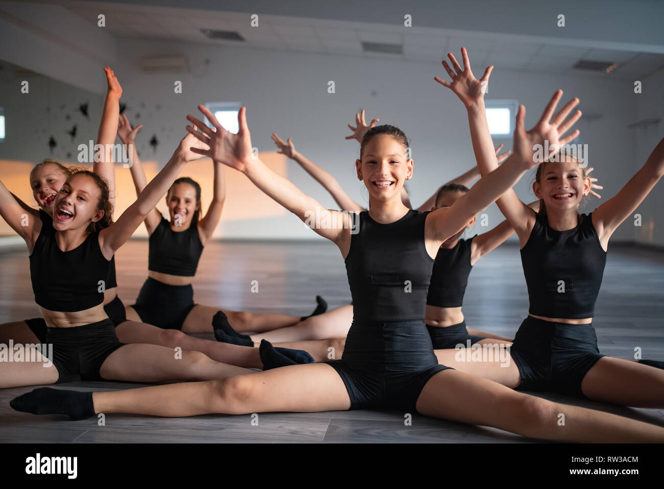 Group of fit happy children exercising ballet and dancing in studio ...