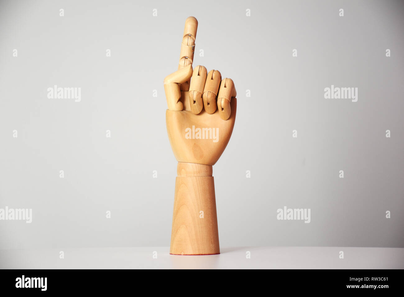 Front view of wooden hand with raised index Stock Photo - Alamy