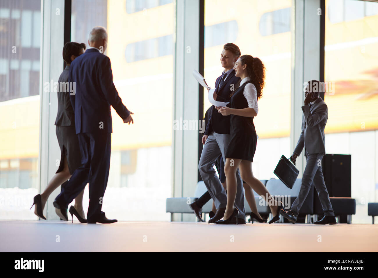 Group of business people walking across office hall of lobby, copy ...