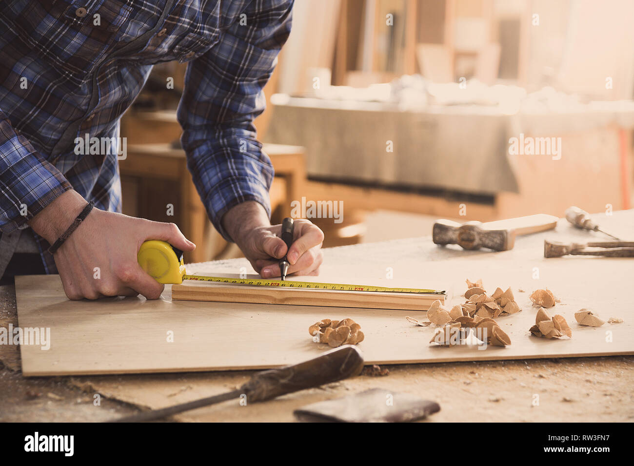 Carpenter working with measure tape, meter or rule taking measures on ...