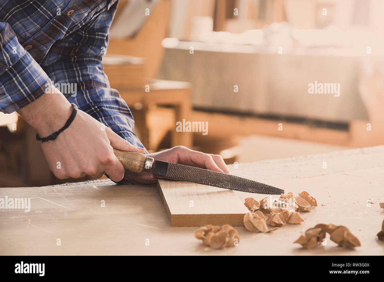 Carpenter working with rasp on wood using rasper. Workshop background ...