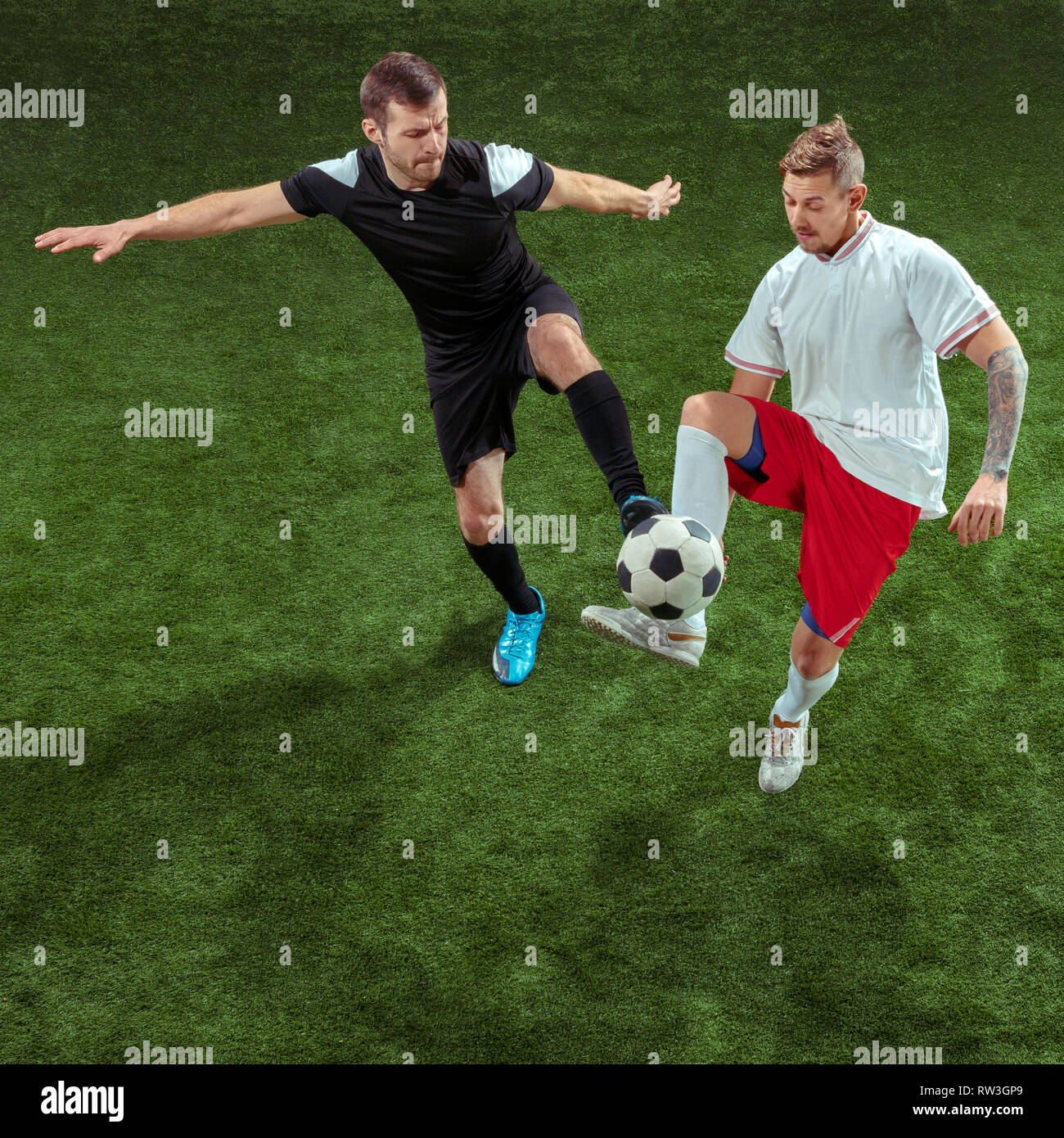 Football player tackling for ball over green grass background ...