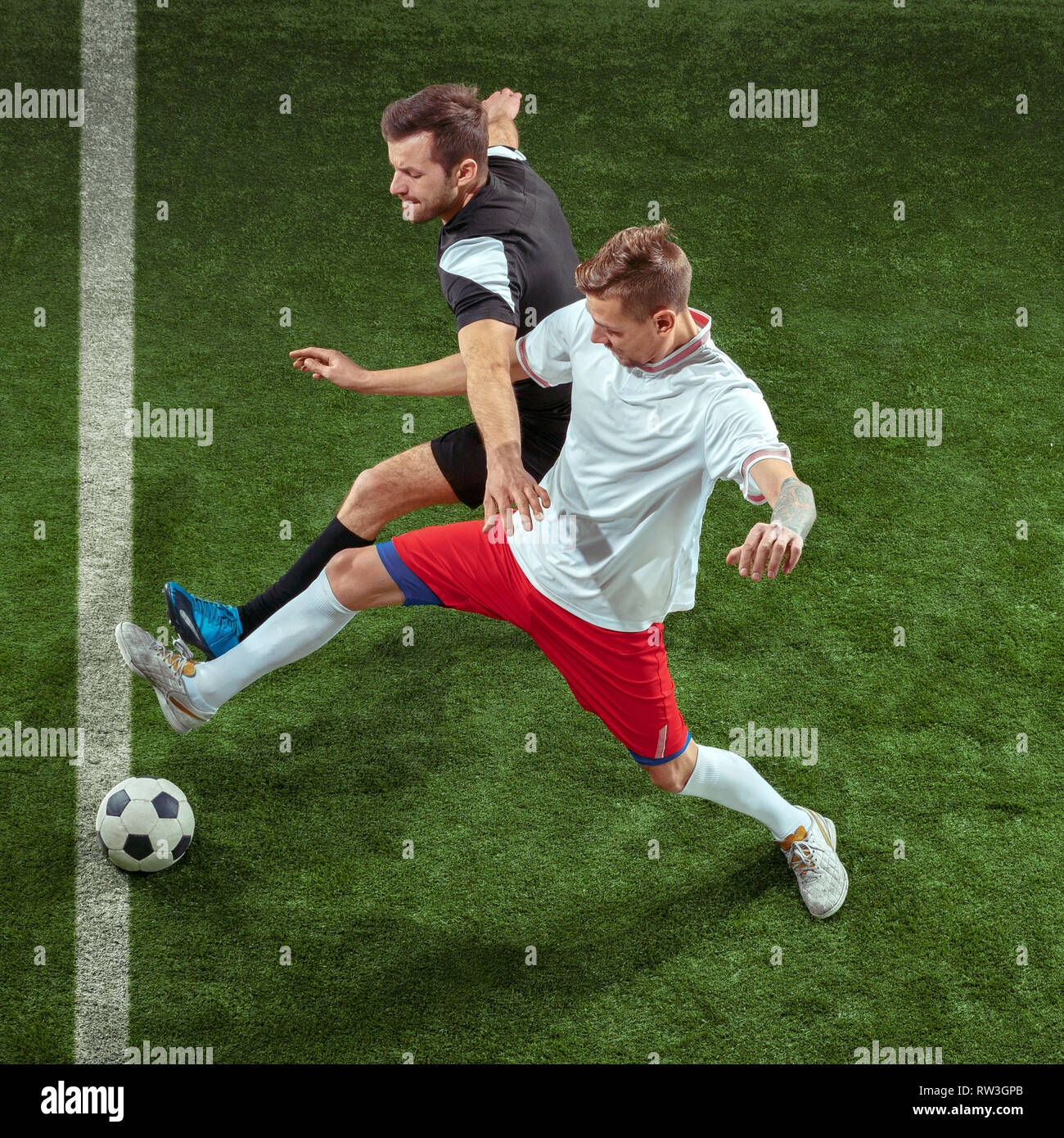 Football player tackling for ball over green grass background ...