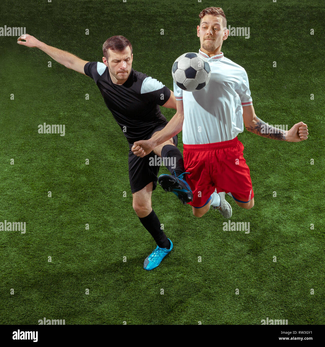 Football player tackling for ball over green grass background ...