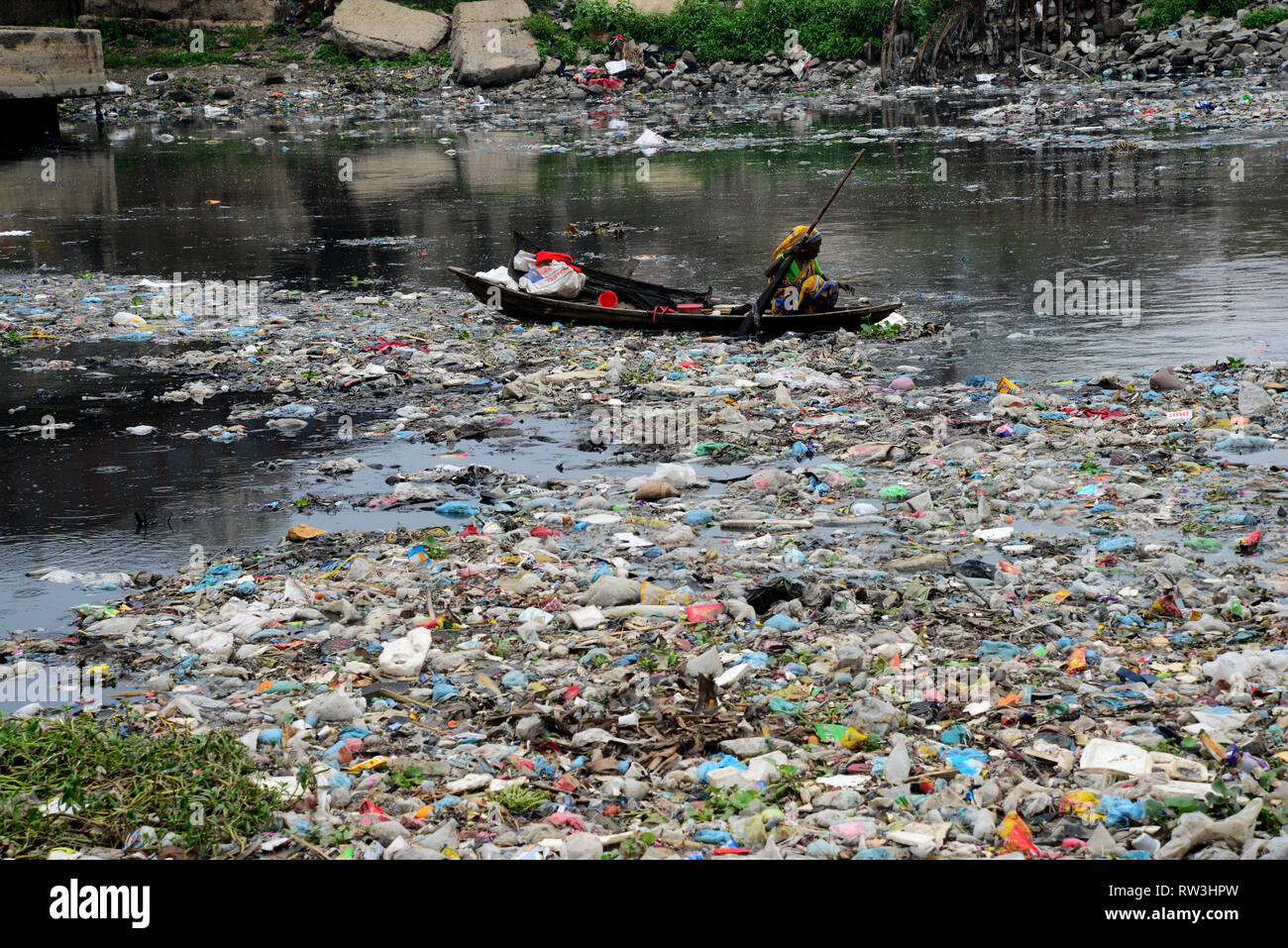 A Bangladesh woman collects plastic from the polluted Turag River in ...