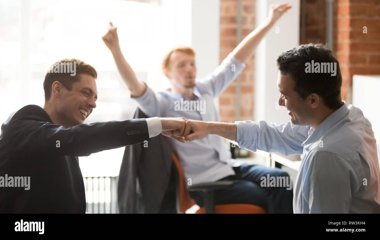 Happy businessmen workers giving fist bump celebrating team project ...