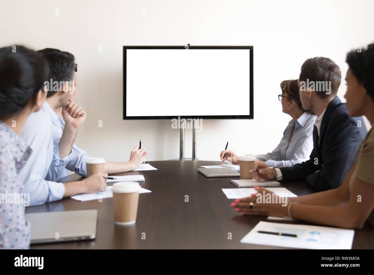 Business people group sitting at conference table looking at screen ...