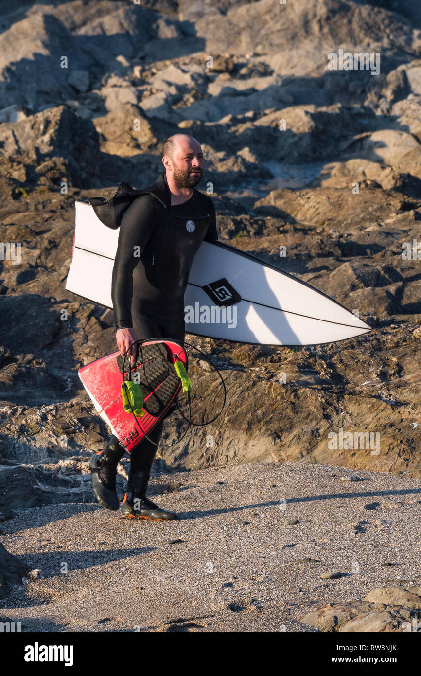 A disconsolate surfer carrying his snapped surfboard at North Fistral ...