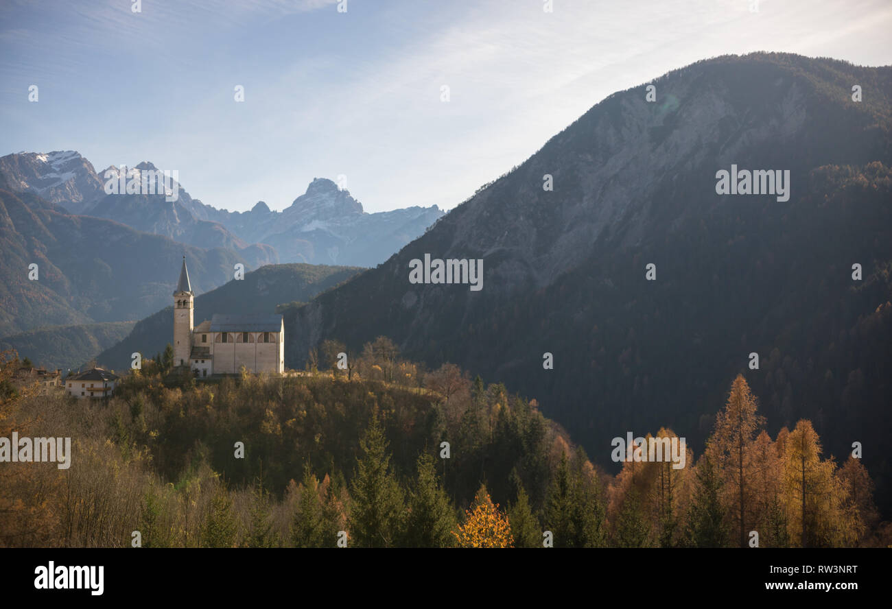 Dolomites nature. Autumn forest and huge mountains. A building on a ...