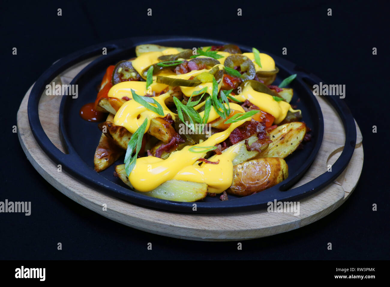 buffalo potato wedges with cheese sauce and jalapeno Stock Photo - Alamy