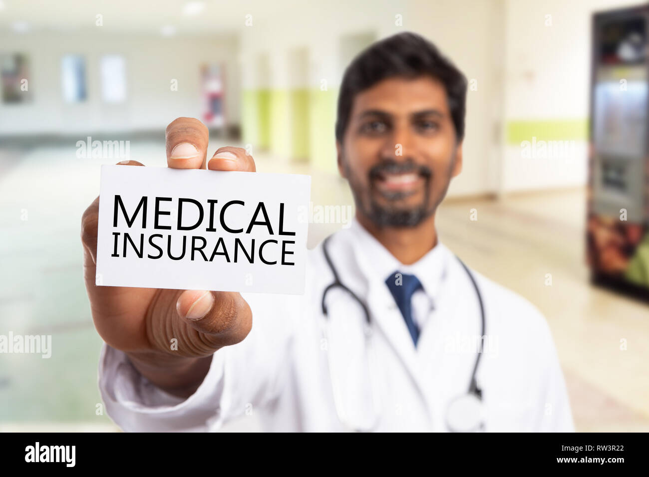 Indian medic holding white business card with medical insurance text ...