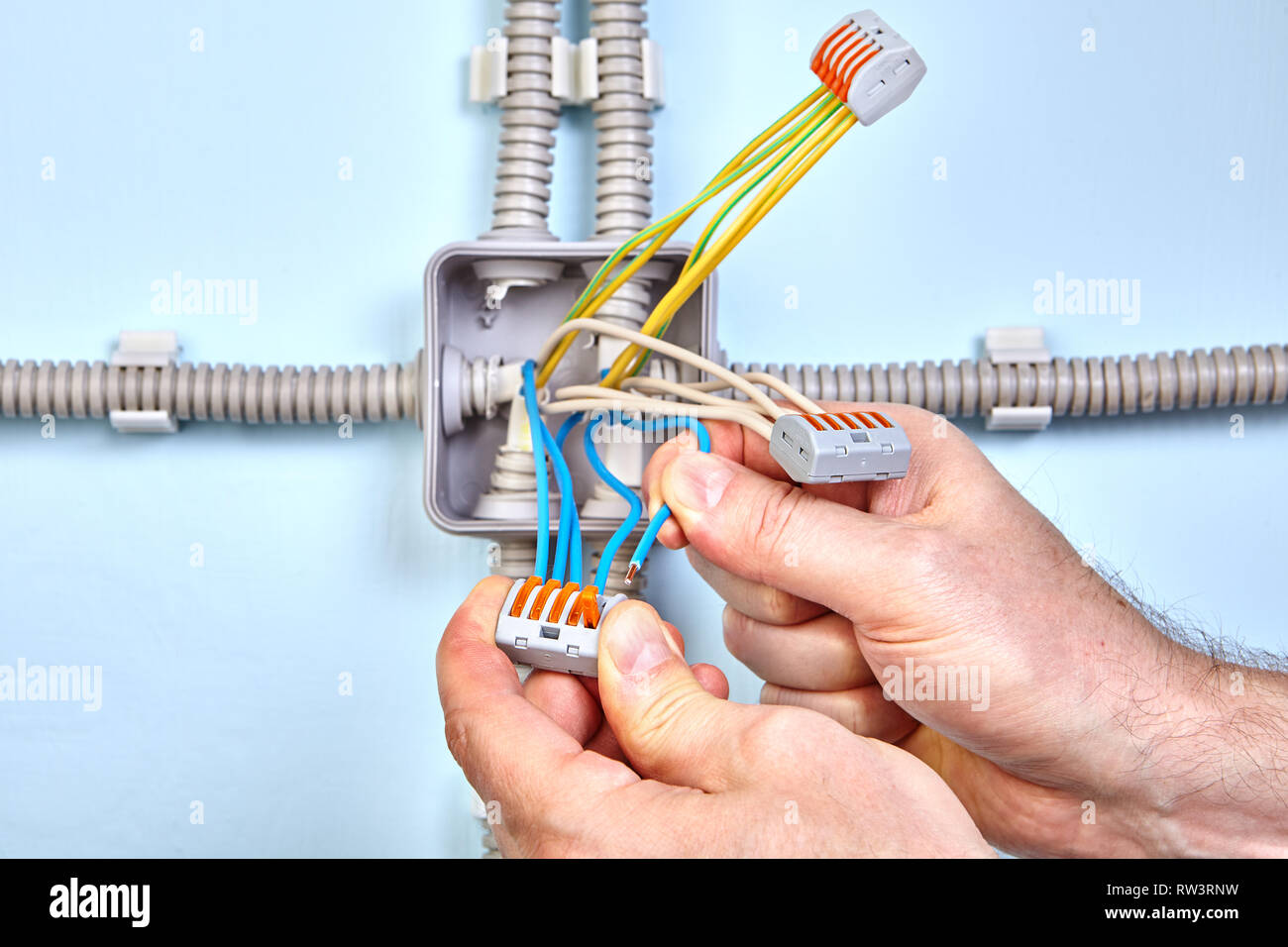 Electrical junction box in process of installation by electrician with ...