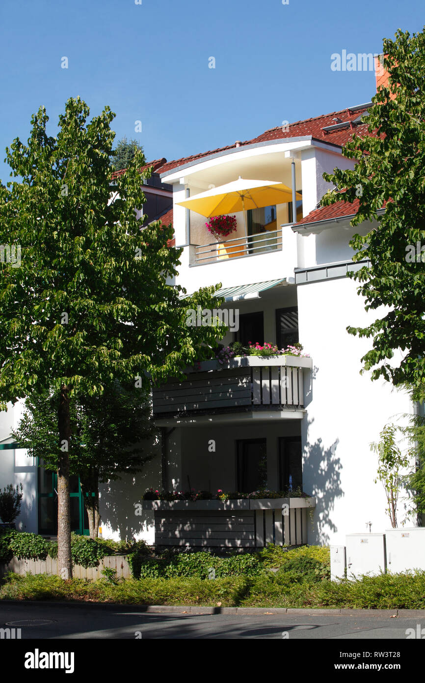 Modern white residential building with balconies and parasol, Achim ...