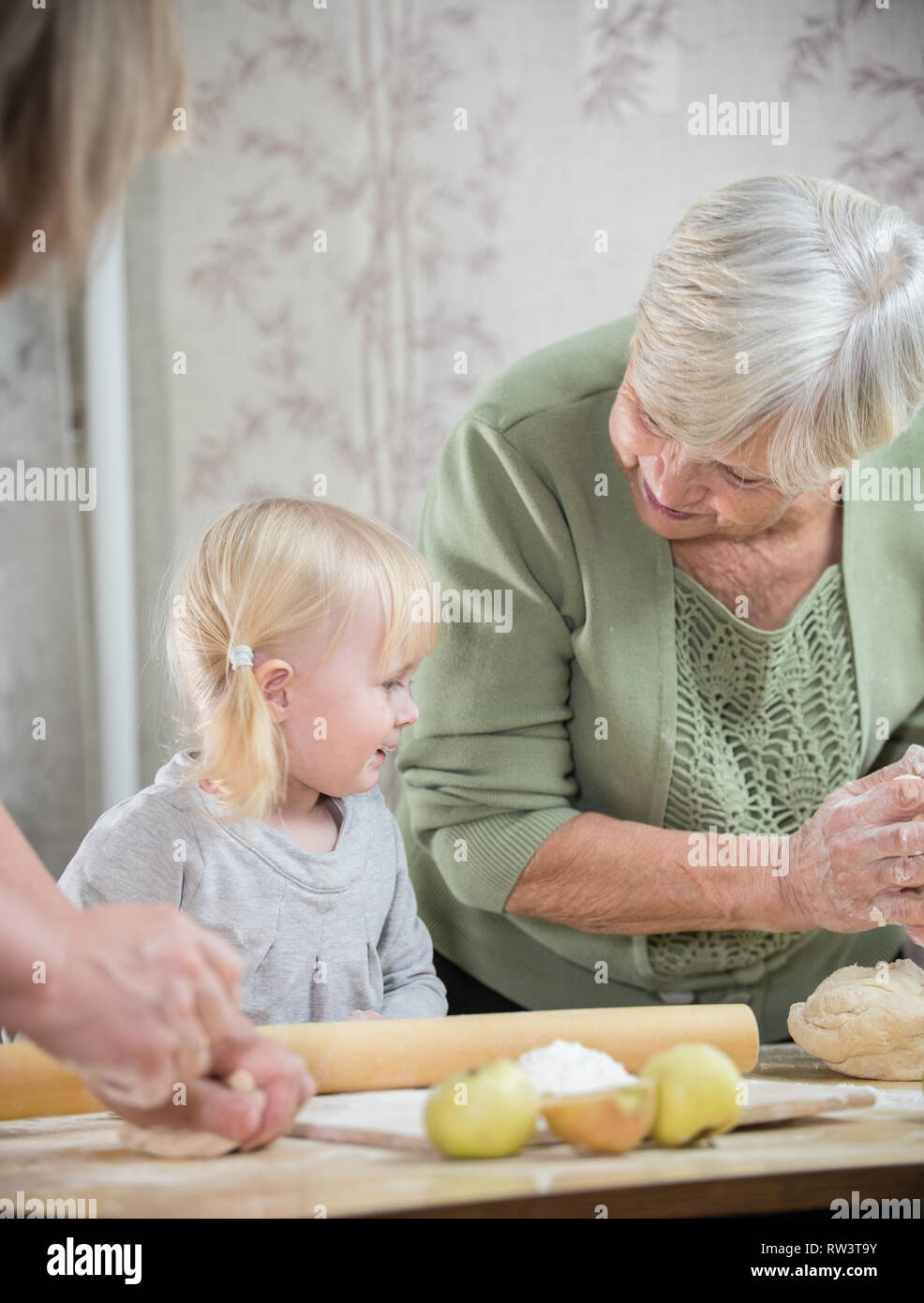 An old lady making little apple pies with a little girl Stock Photo - Alamy