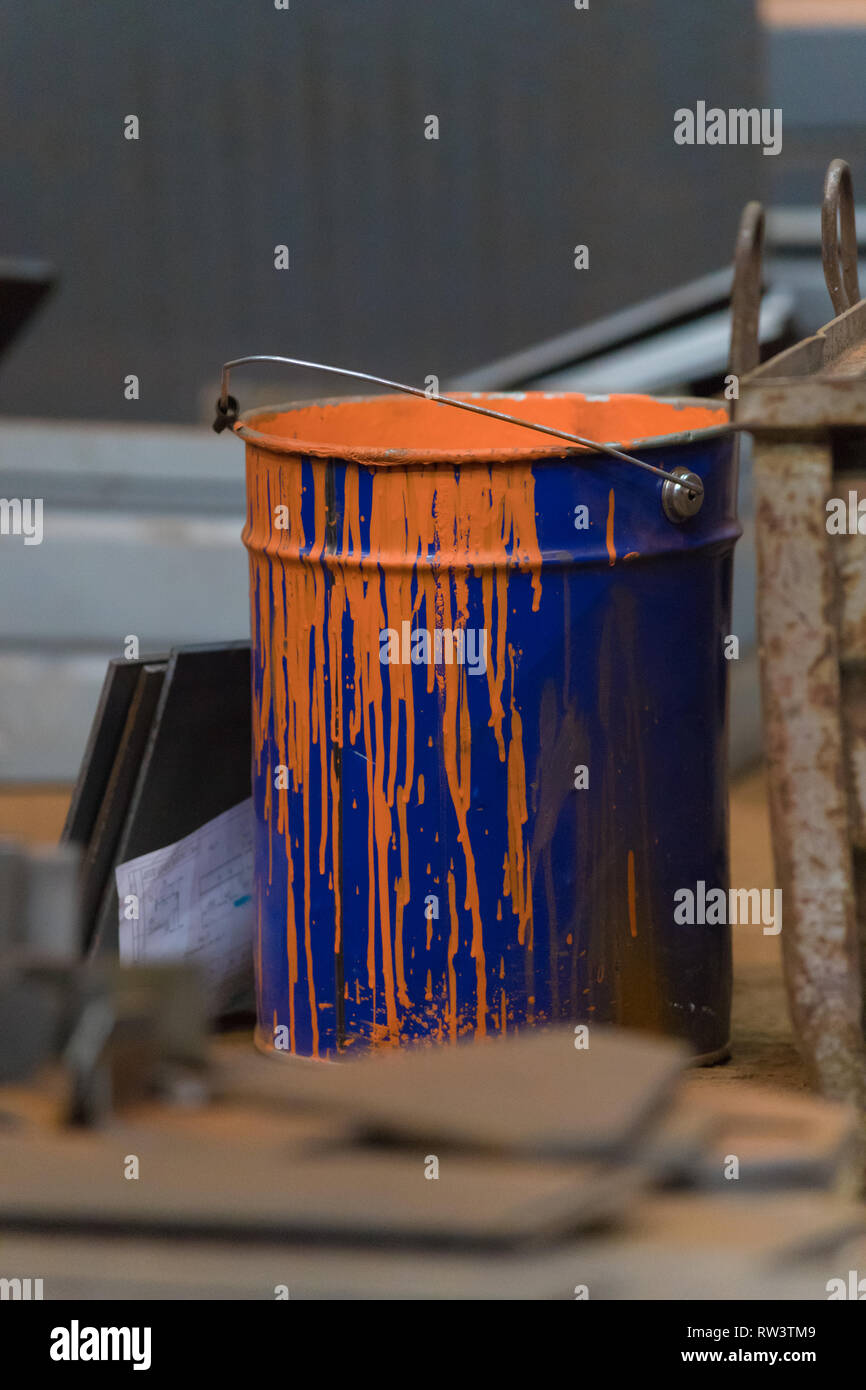 Industrial concept. A bucket with orange paint inside Stock Photo - Alamy