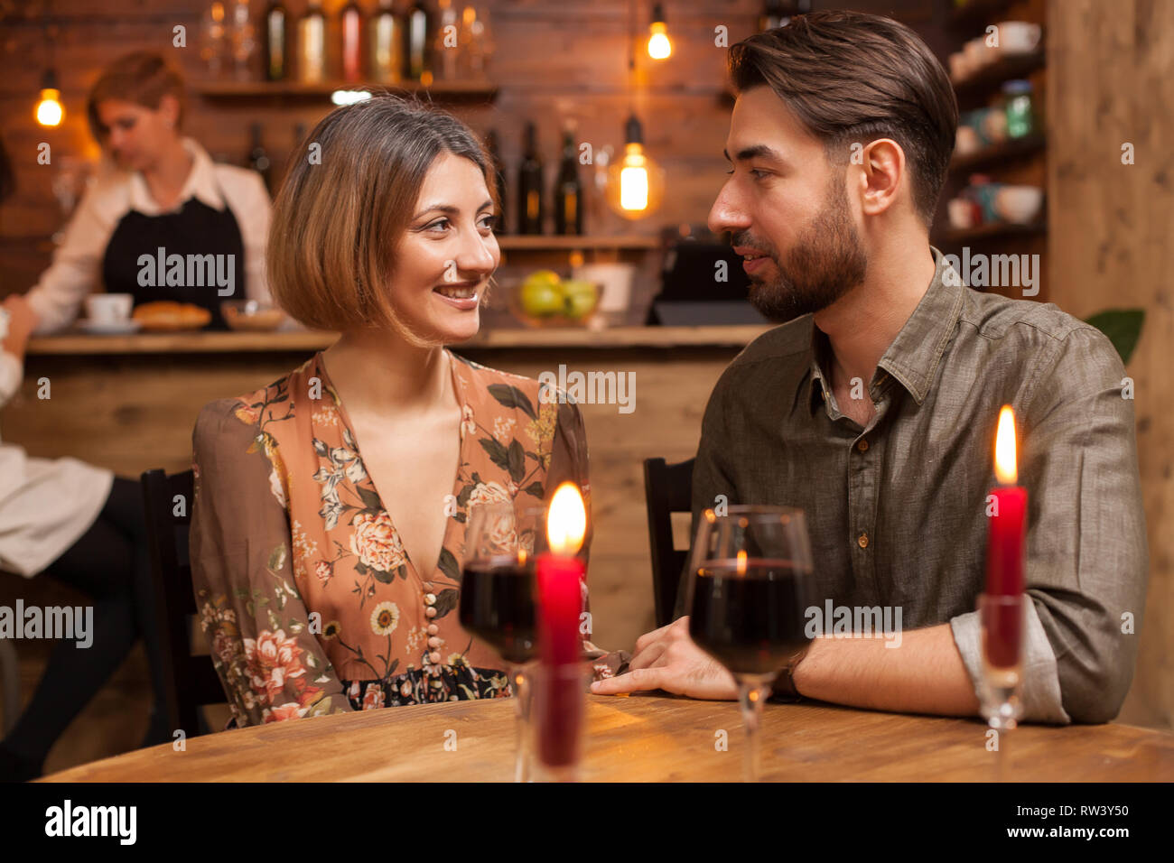 Stylish couple on a romantic date looking deeply into each others eyes ...
