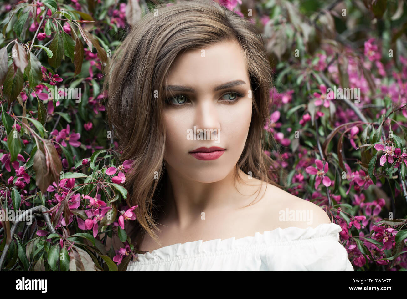 Pretty woman in spring. Beautiful girl on floral nature background ...